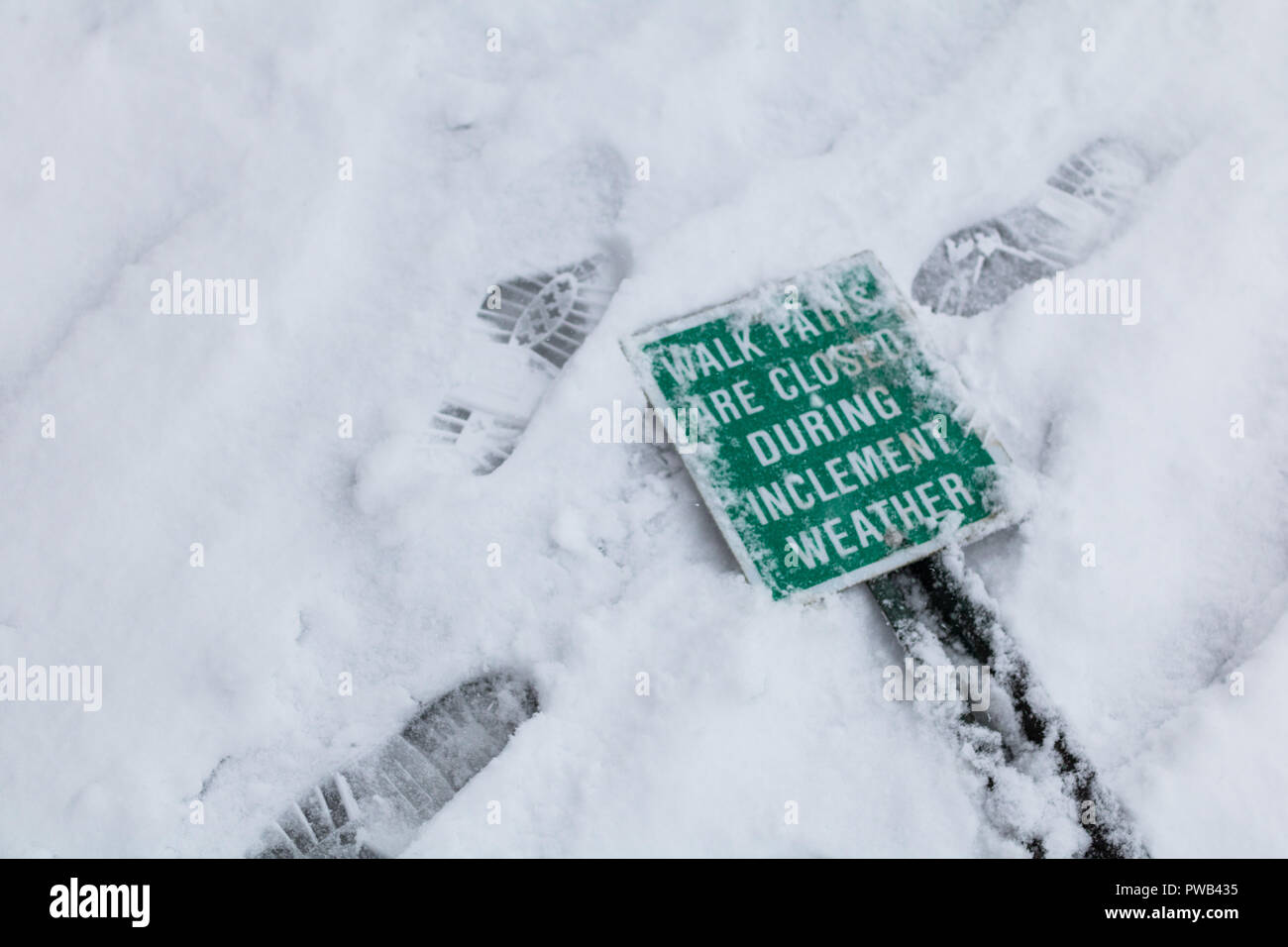 Fallen sign in the snow, walked on Stock Photo - Alamy