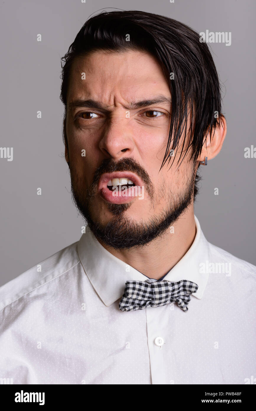Face of handsome man looking angry against gray background Stock Photo ...