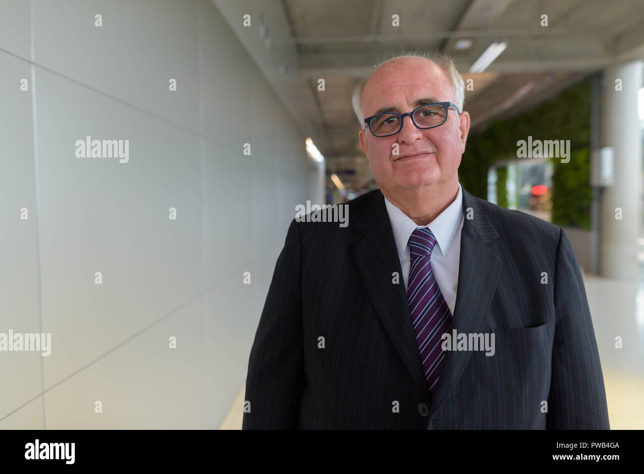 Overweight senior businessman lounging around the airport of Ban Stock ...