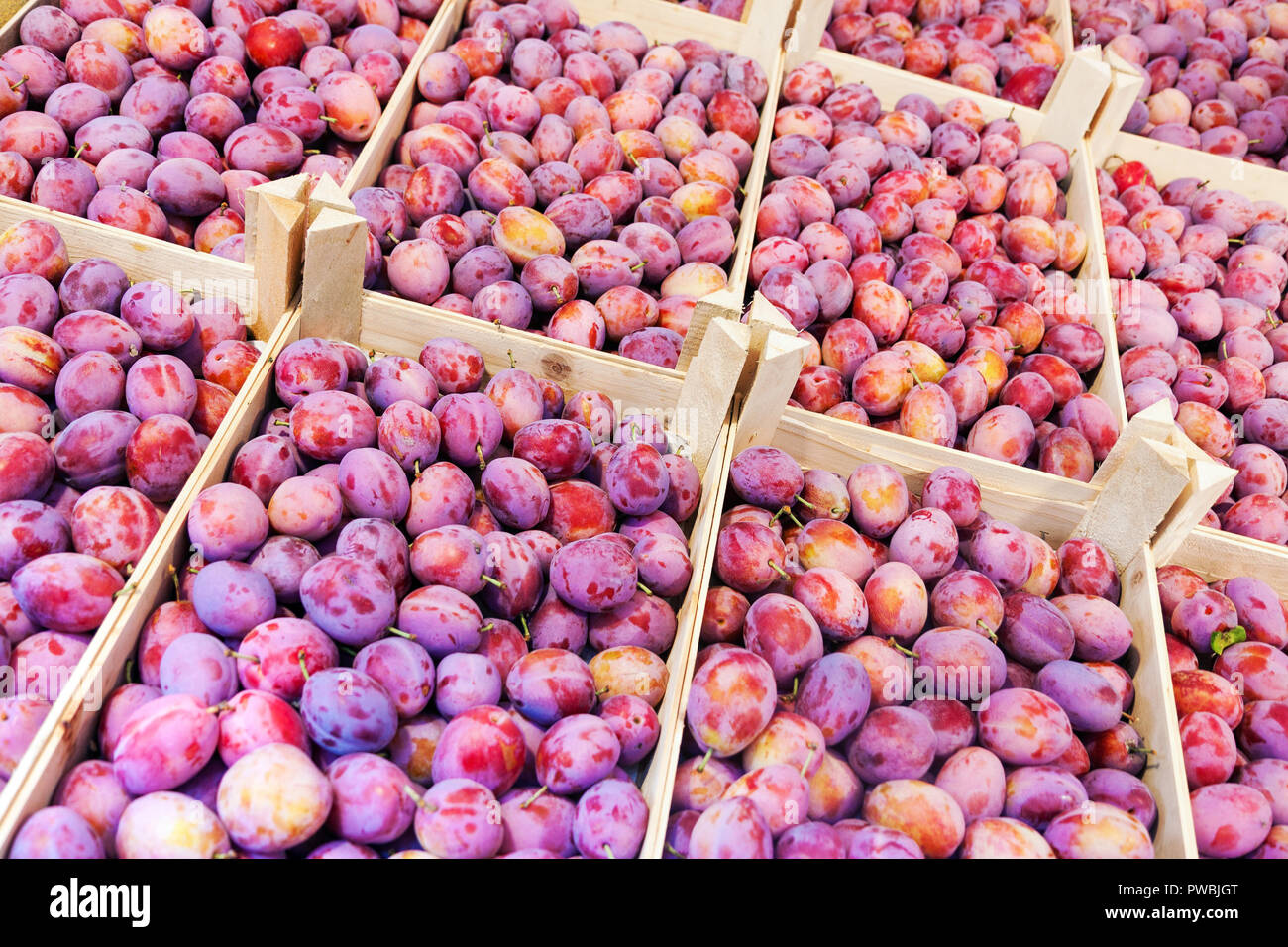 Fresh plum fruits in wooden boxes for sale at market, natural food ...