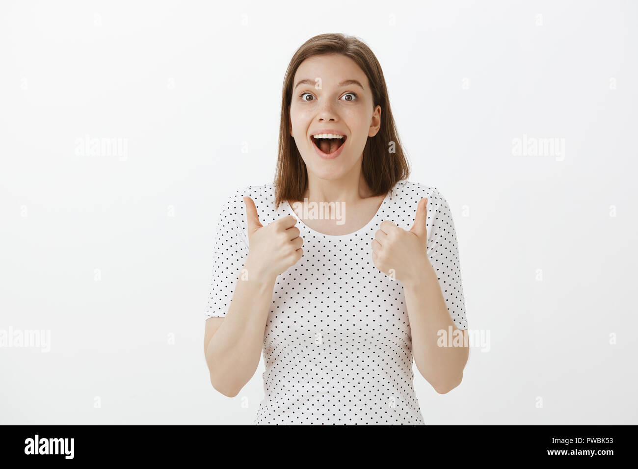 Supportive happy girl agrees with friend, smiling broadly and raising ...