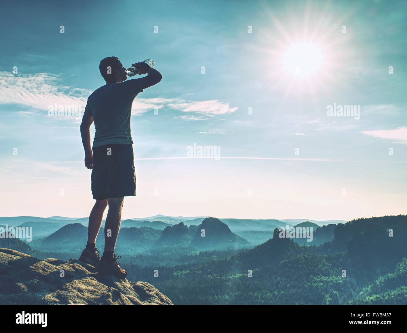 Sportsman drinking water in nature. Sweaty tired man drink water after ...