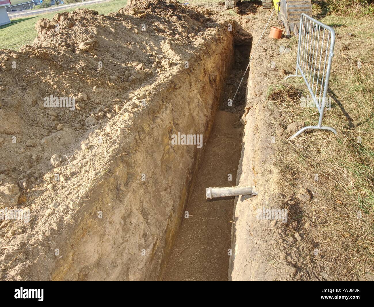 Repairing of plastic tube water delivery system. Open trench with small ...