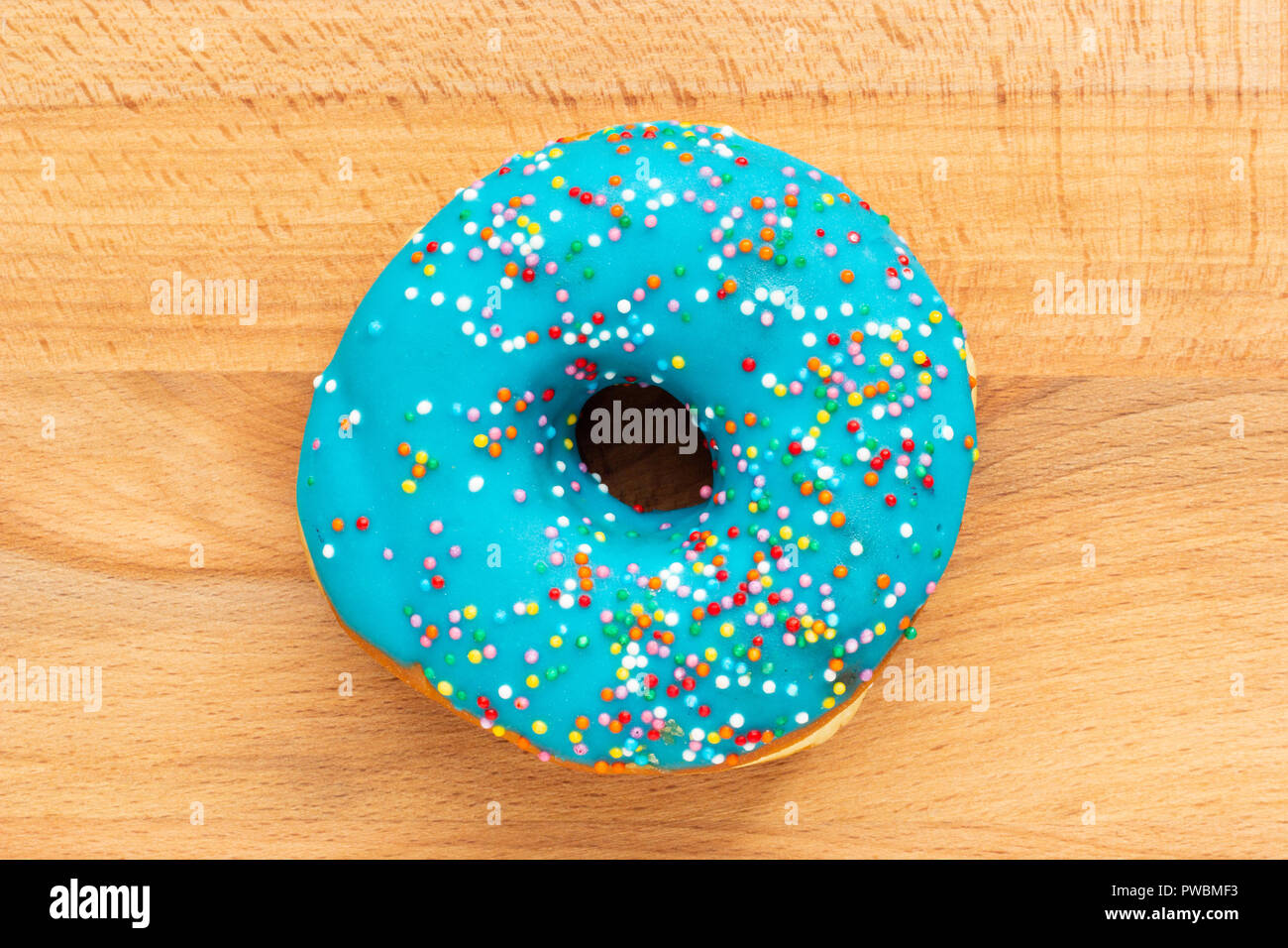 Donut blue with sprinkles isolated on wooden background Stock Photo - Alamy