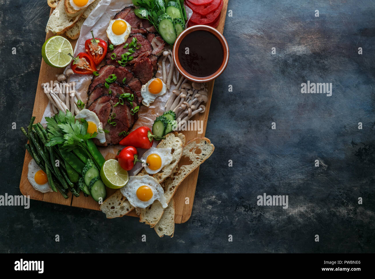 Breakfast board fullof eggs, meat, vegetables, bread, meat and tea, top ...