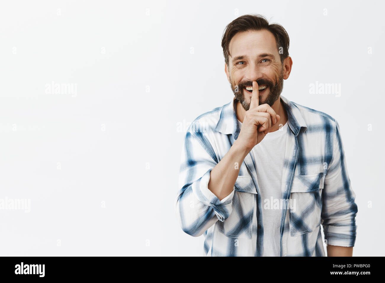 Wanna hear secret. Portrait of excited handsome adult man with beard ...