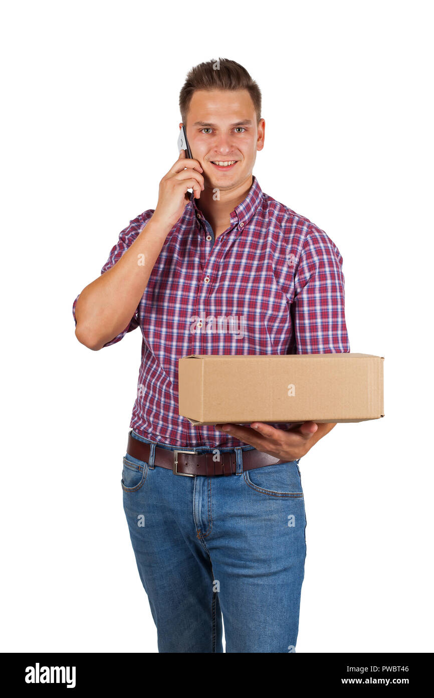 Handsome delivery man holding shipment to customer while having a call ...