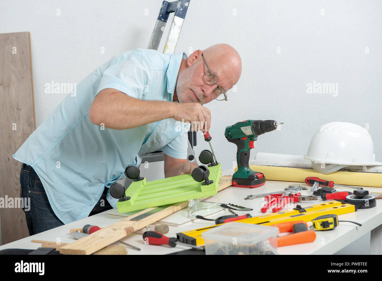 a mature man using screwdriver at home Stock Photo - Alamy