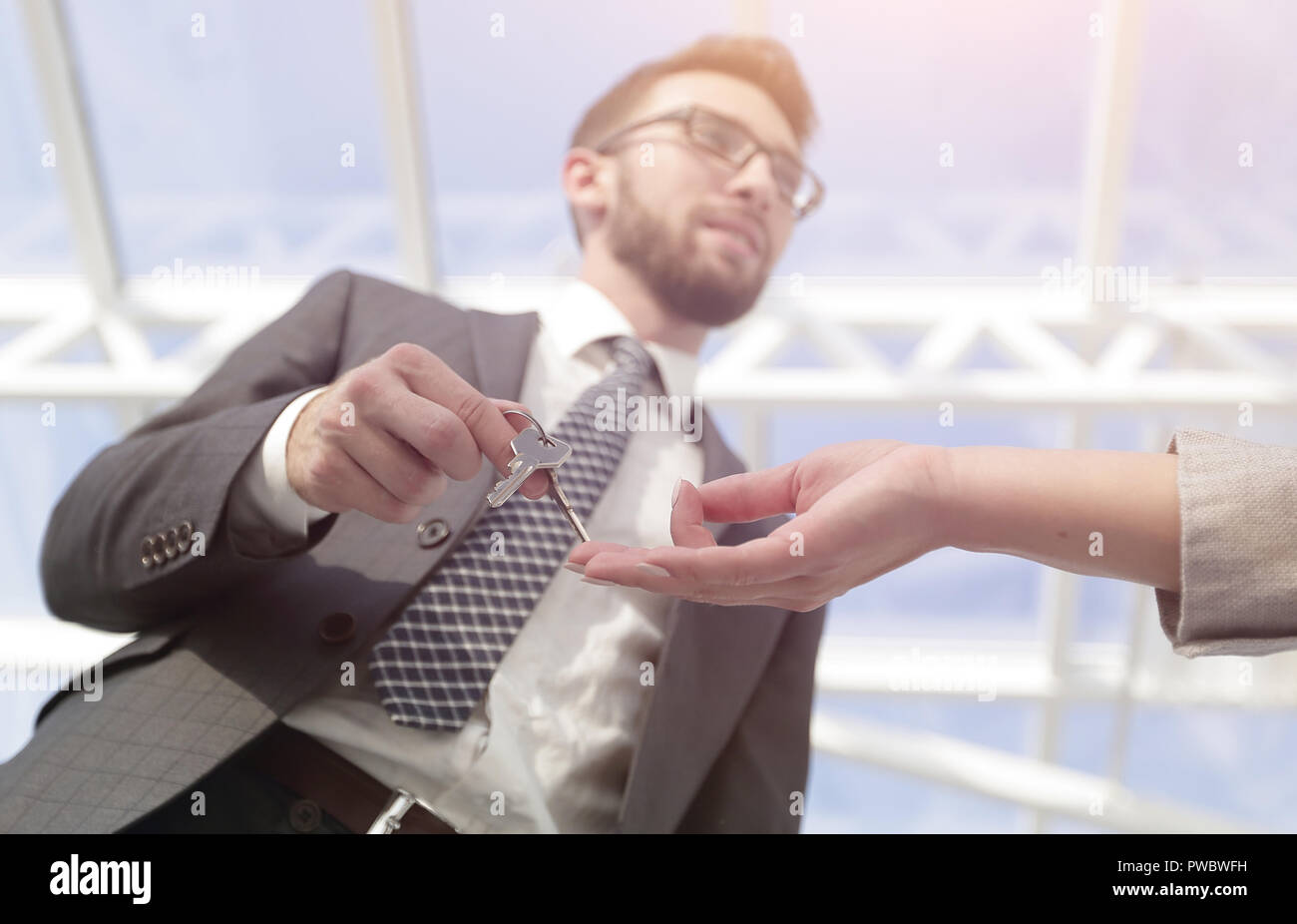 Cropped image of estate agent giving house keys to man in office Stock ...