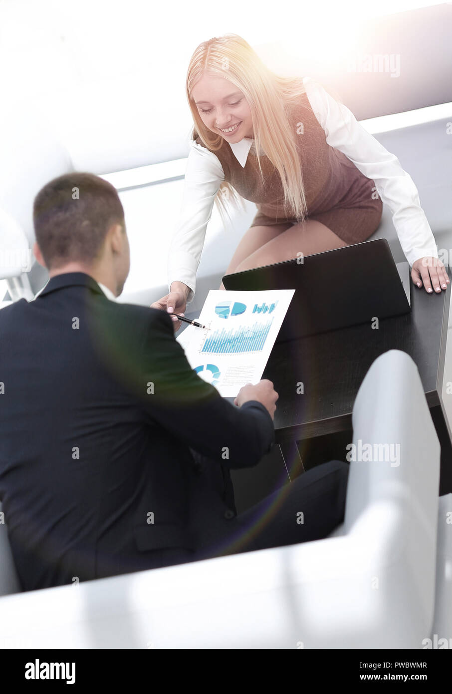 Finance staff discussing financial charts in the lobby of the office ...