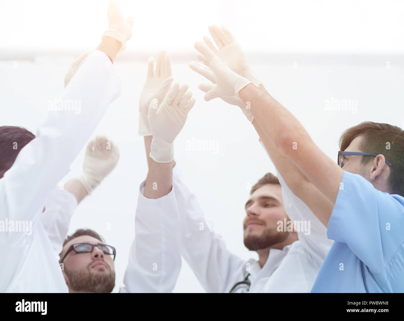 surgical team raising their hand Stock Photo - Alamy