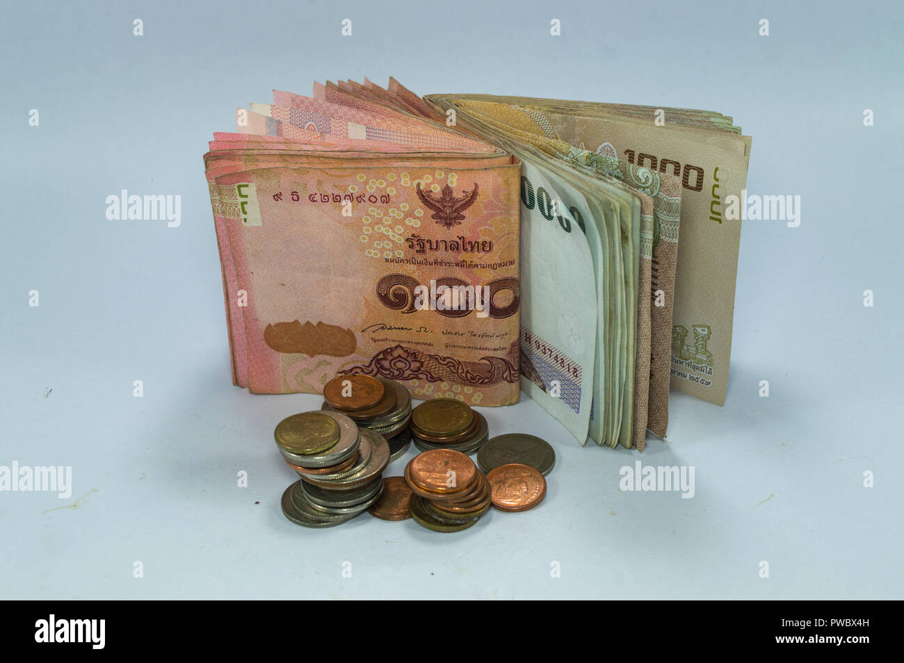 Thai baht banknotes and coins on white background Stock Photo - Alamy
