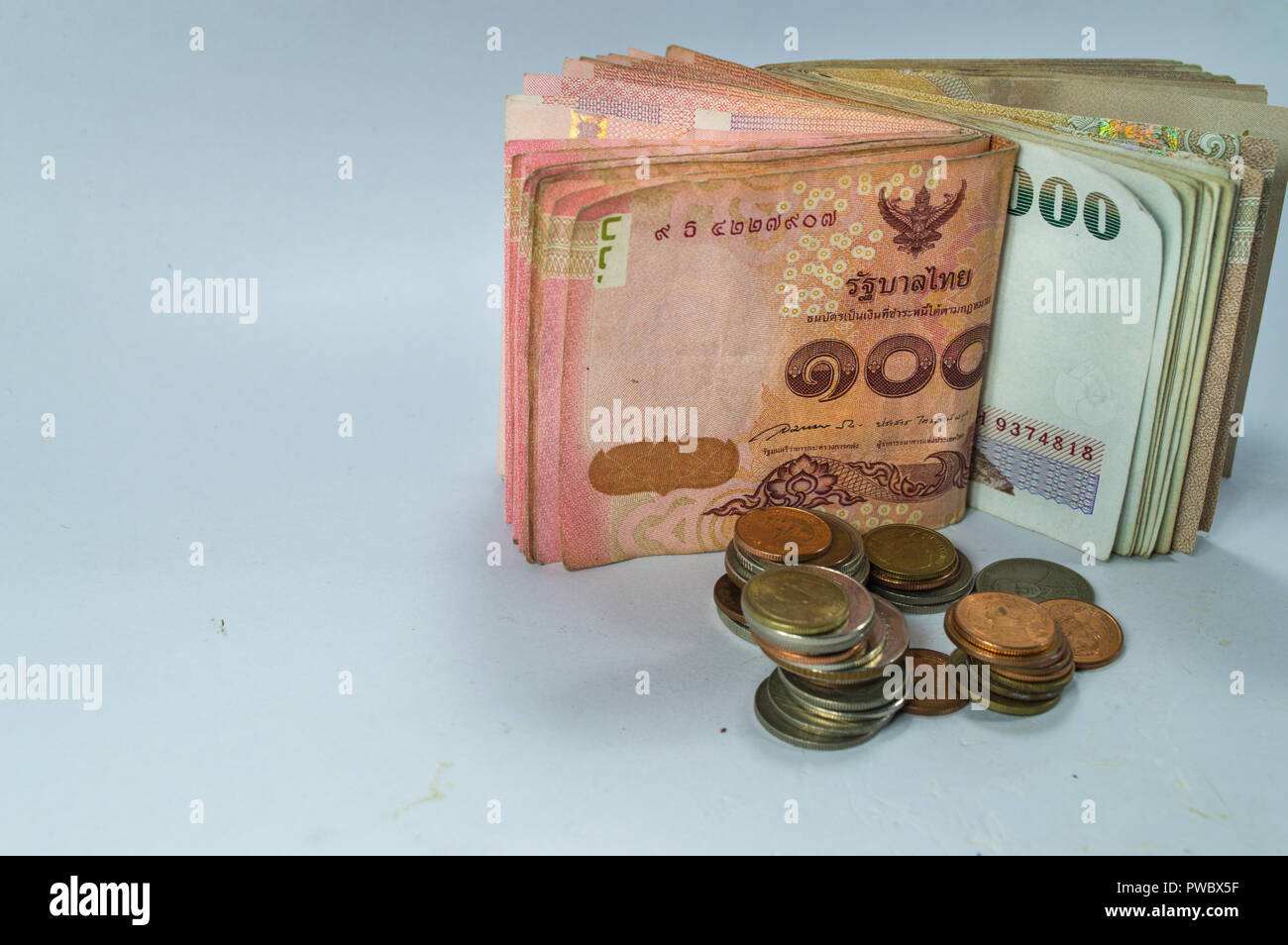 Thai baht banknotes and coins on white background Stock Photo - Alamy
