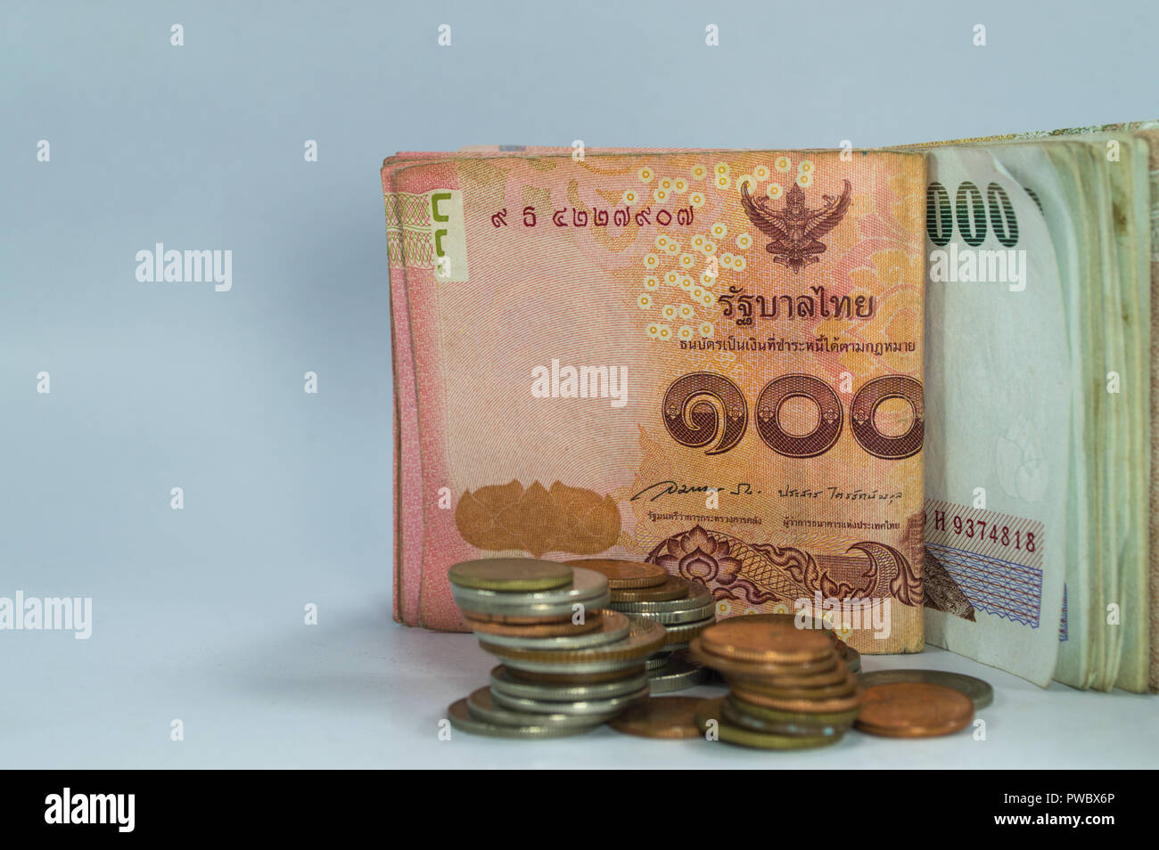 Thai baht banknotes and coins on white background Stock Photo - Alamy