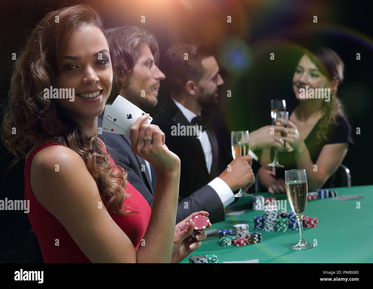 young brunette woman playing poker on black background Stock Photo - Alamy