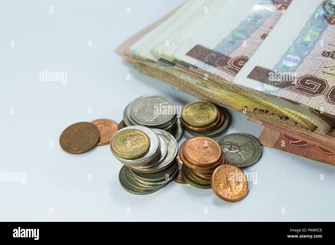 Thai baht banknotes and coins on white background Stock Photo - Alamy