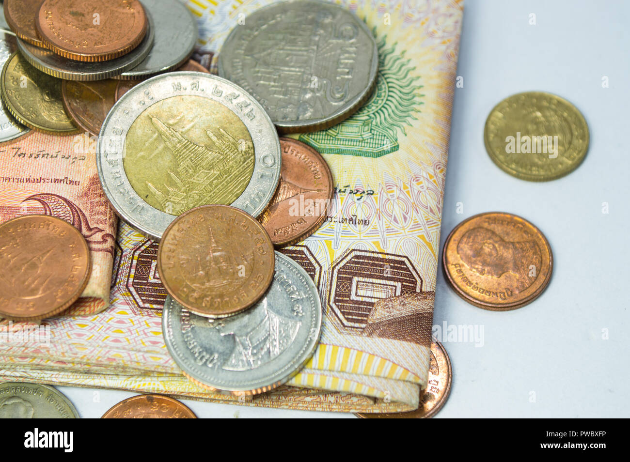 Thai baht banknotes and coins on white background Stock Photo - Alamy