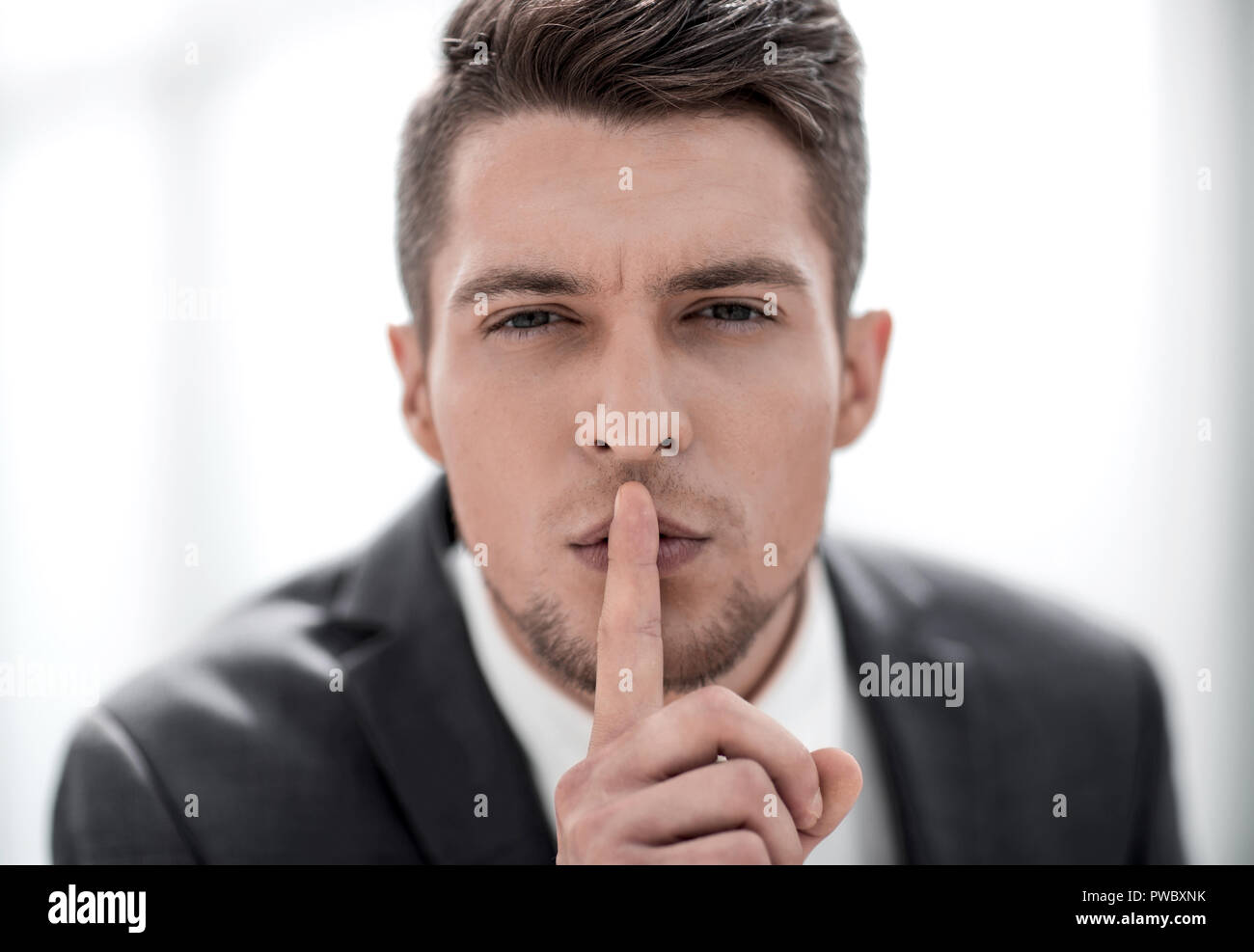 Portrait businessman showing silence gesture hi-res stock photography ...