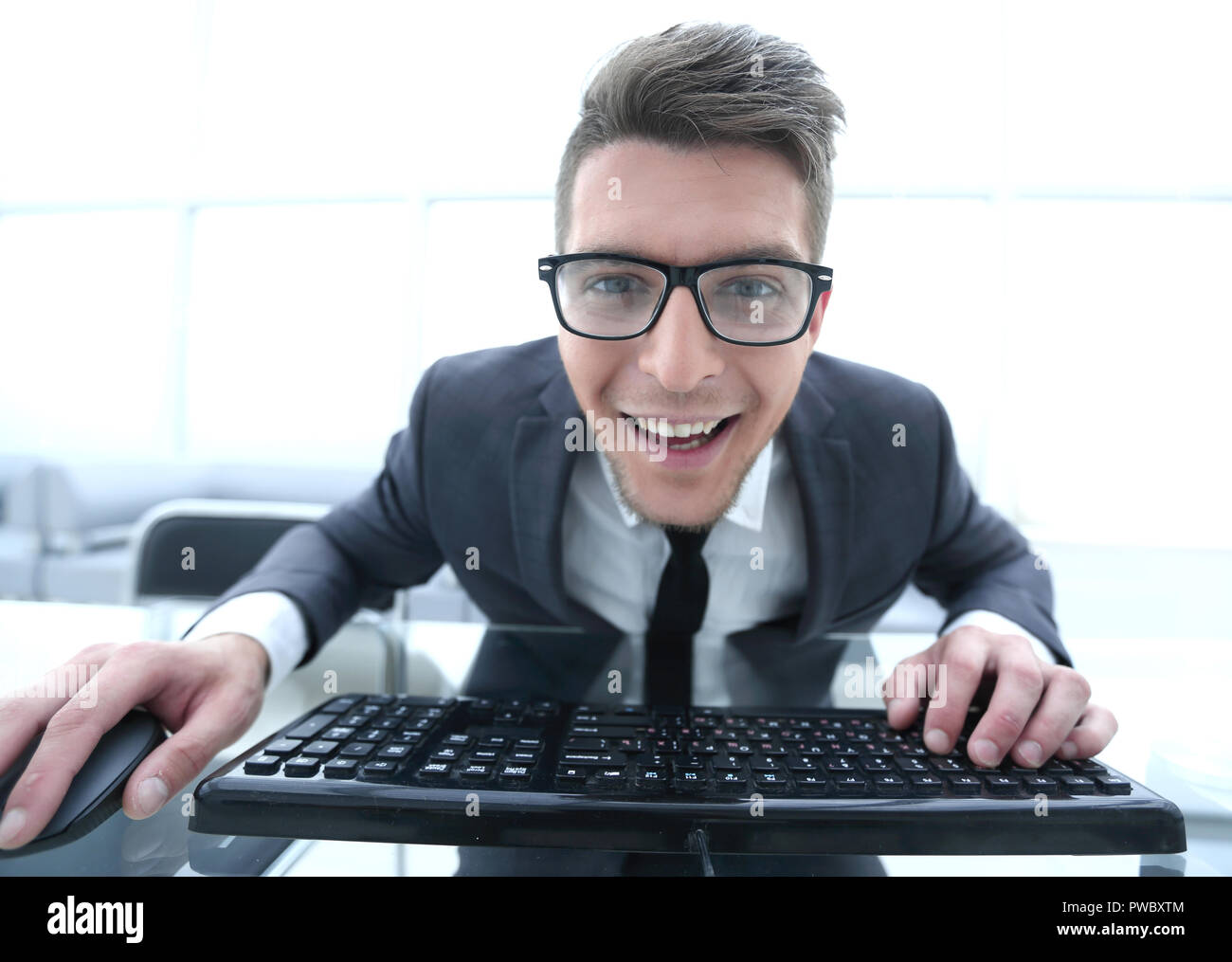 Crazy looking nerdy man typing on the keyboard Stock Photo - Alamy