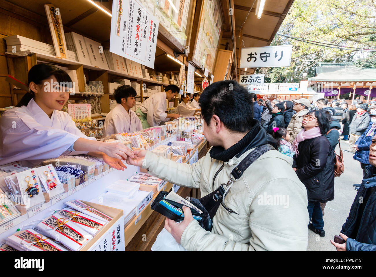 Japanese new year, shogatsu. People at busy counter of shrine office ...