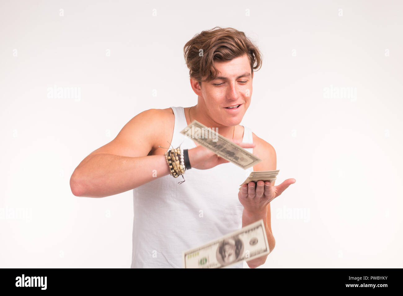 Rich, fun and finance concept - handsome young man throws money over ...