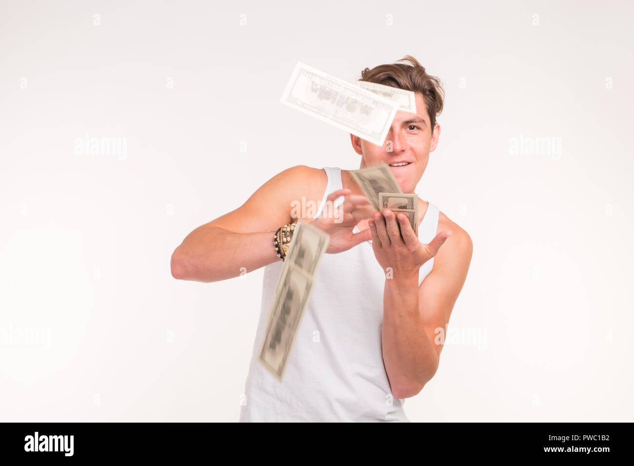 Rich, fun and finance concept - handsome young man throws money over ...