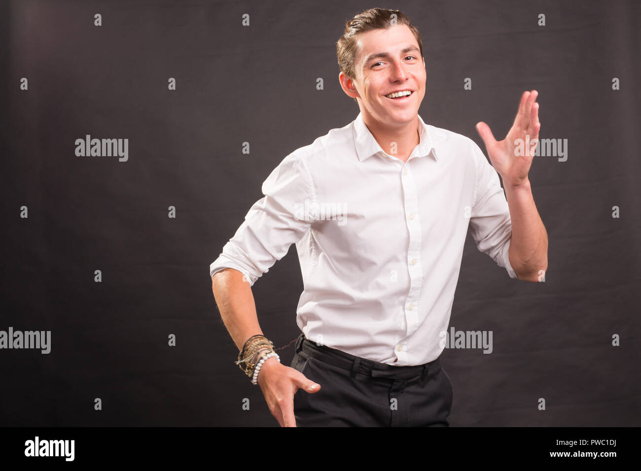 People, gesture and fashion concept - young handsome man waving his ...