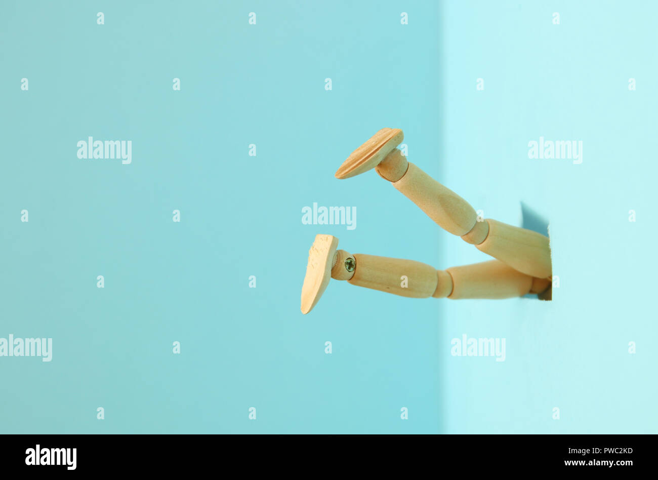 concept image of wooden dummy stuck upside down. stress and danger ...