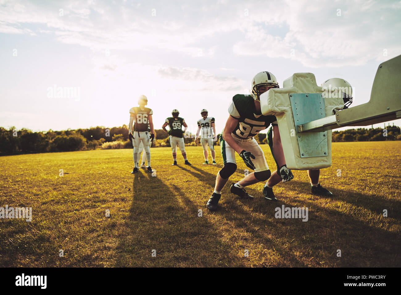 Group of young American football players practicing defence and tackles ...