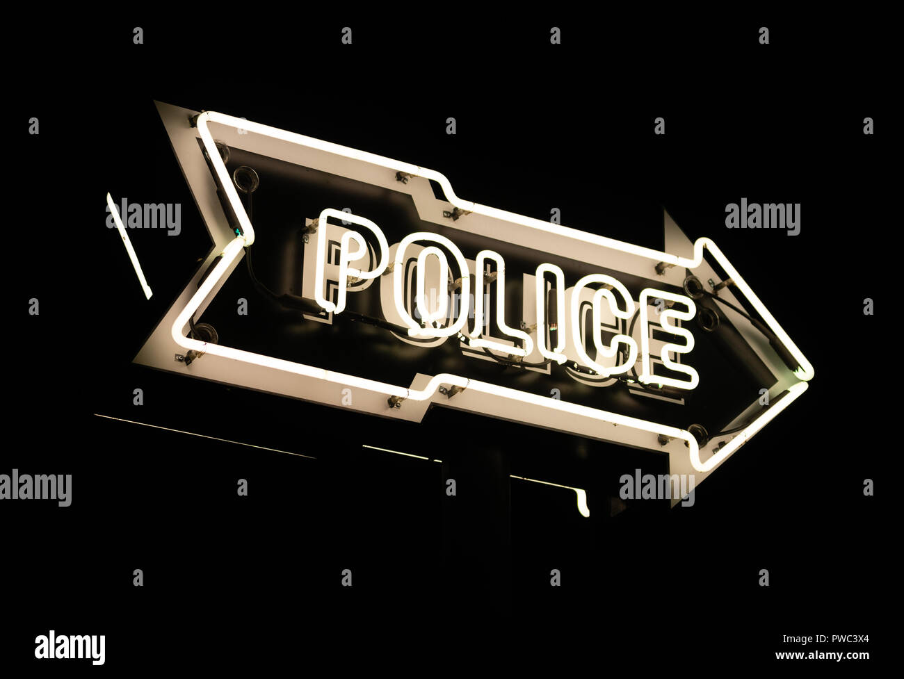 It's a dark sky behind a simple white neon arrow with the word POLICE ...