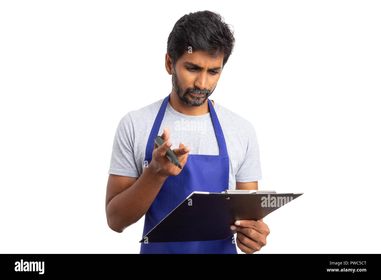 Indian male store manager looking at vendor checklist with concerned ...