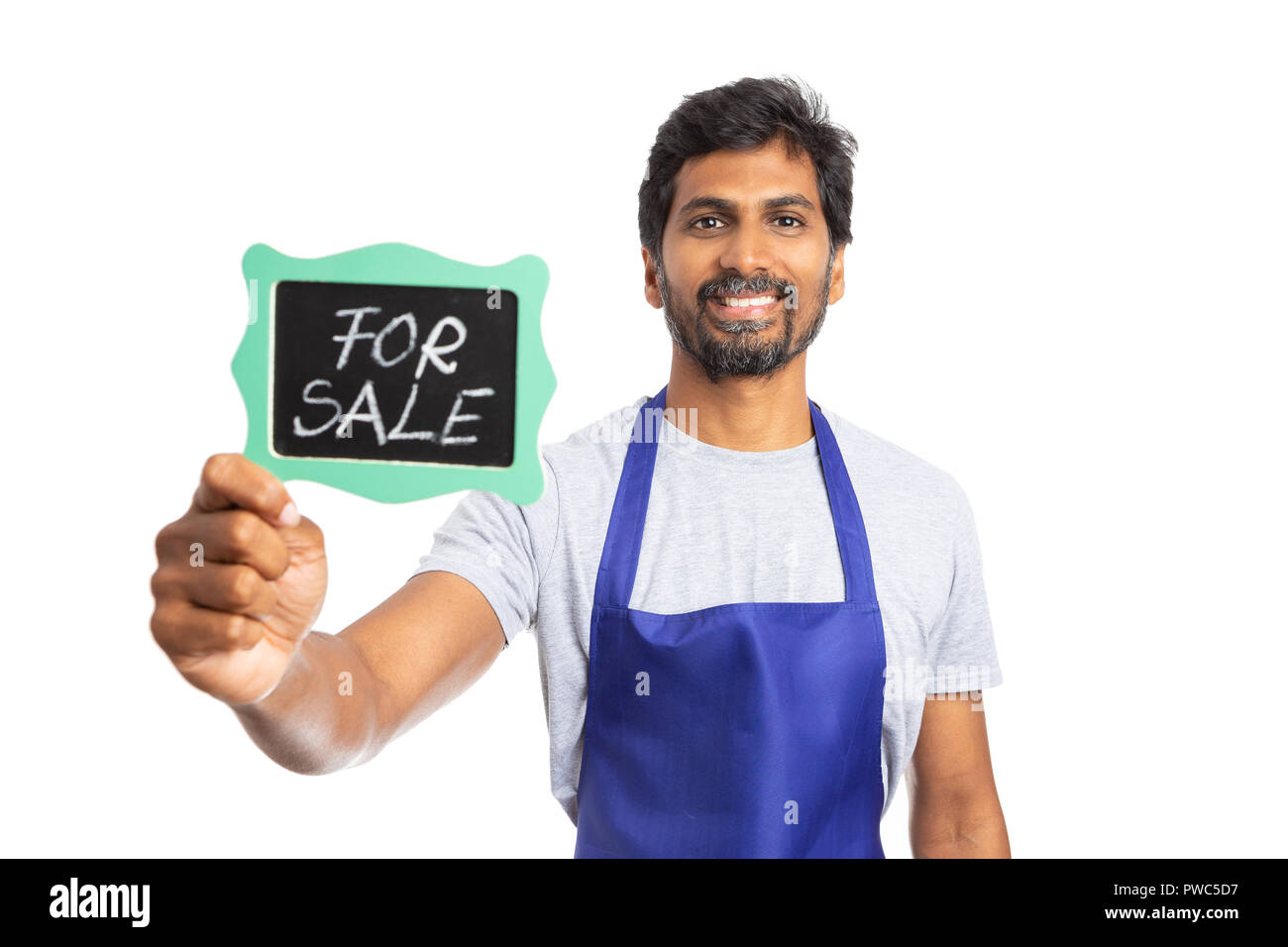 Friendly business owner or store manager presenting for sale sign ...