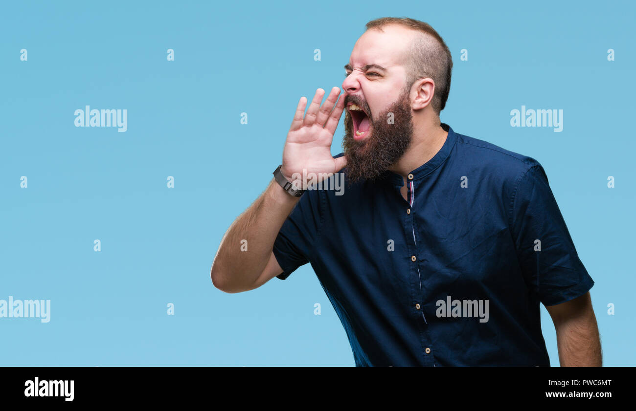 Young caucasian hipster man over isolated background shouting and ...