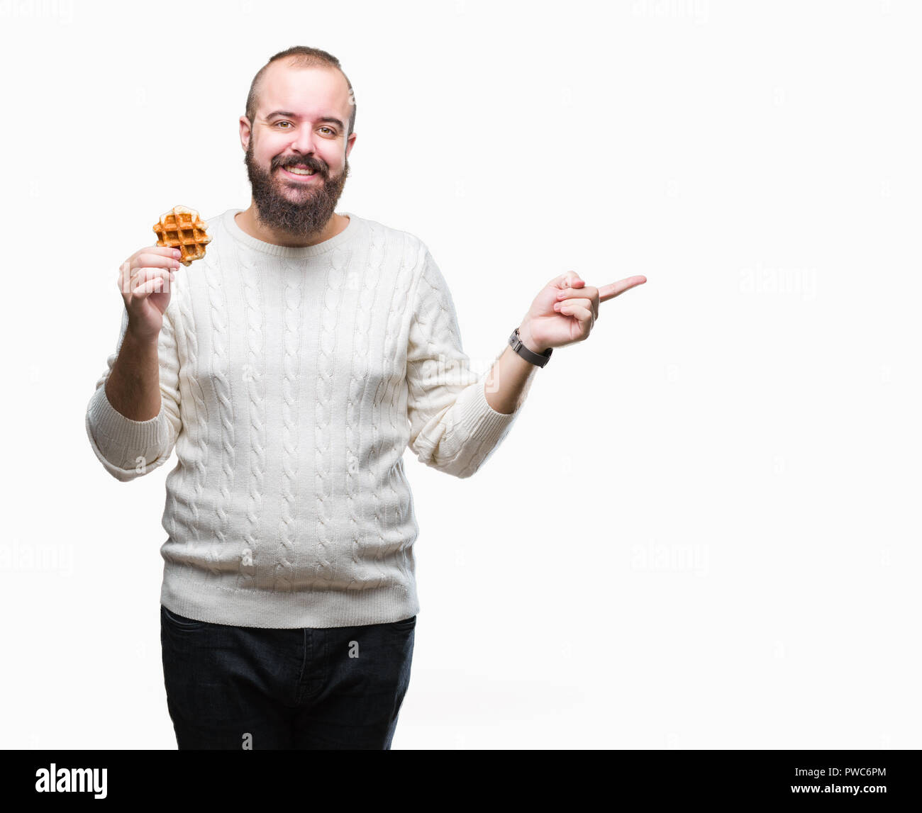 Young caucasian hipster man eating sweet waffle over isolated ...
