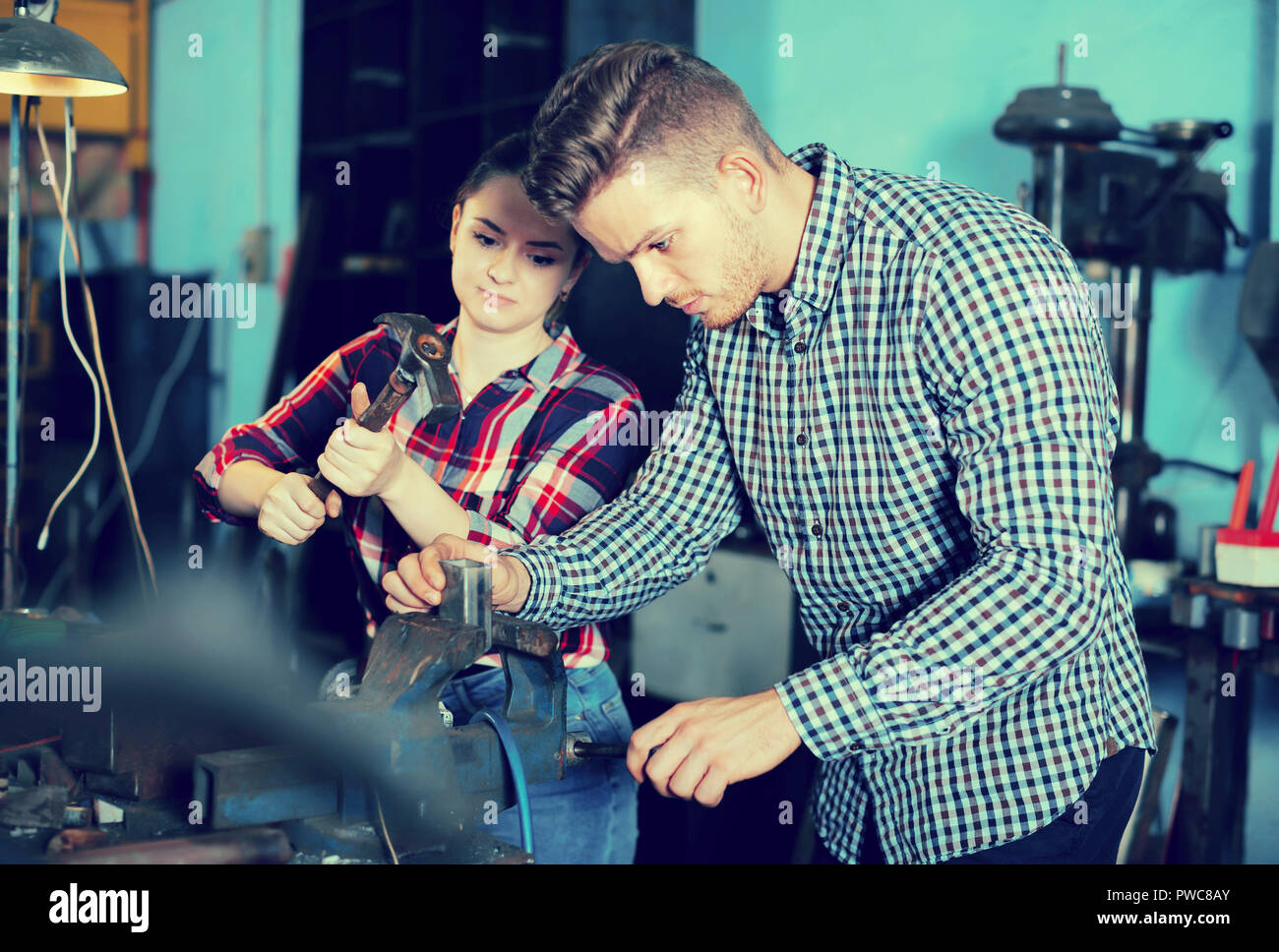 Two happy masters are standing with tools near table and working in ...