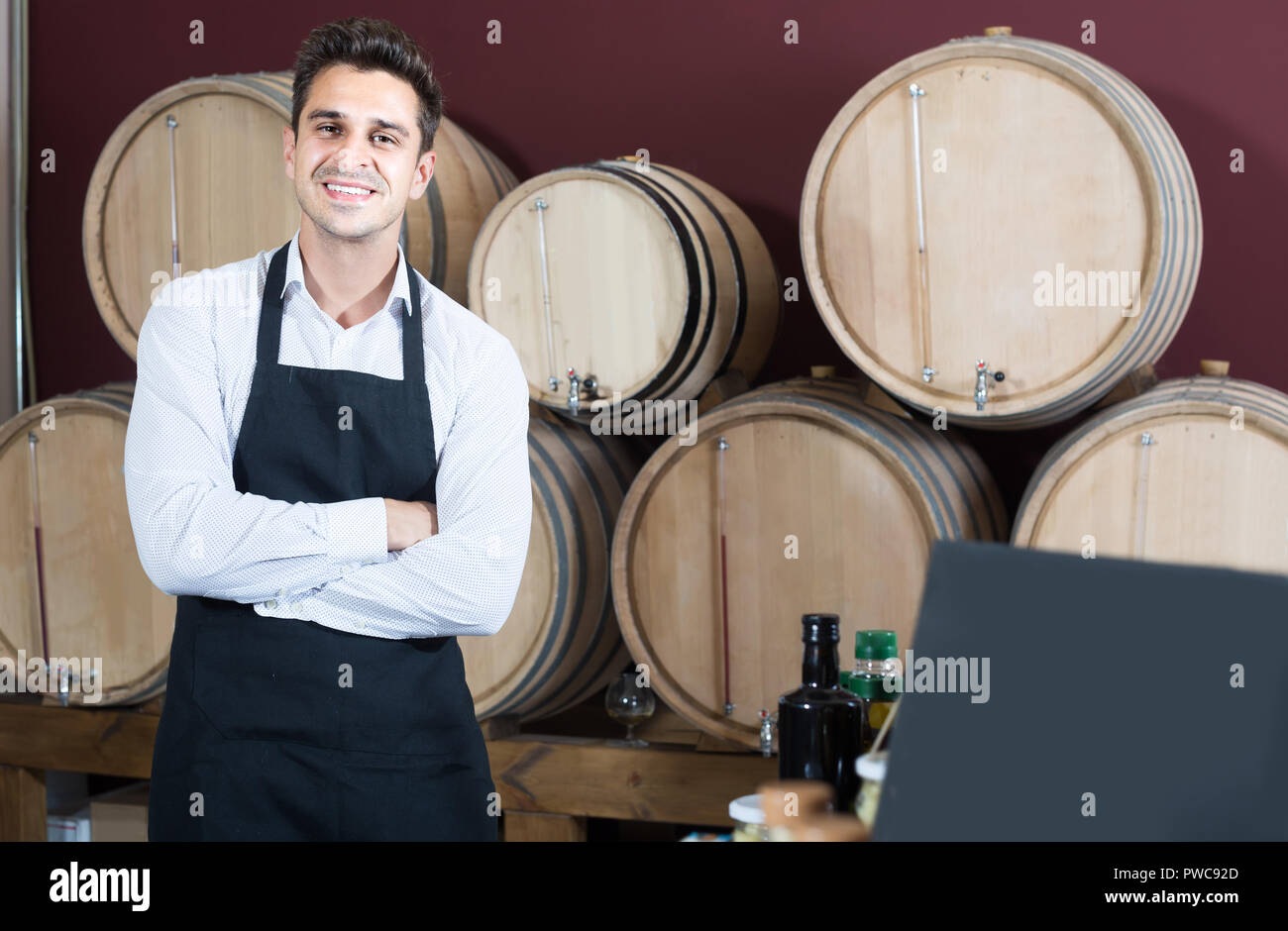smiling russian man in uniform standing in store wine section with ...