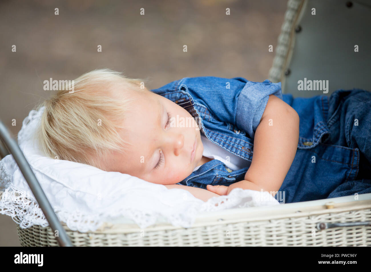 Little newborn baby boy, sleeping in old retro stroller in forest ...