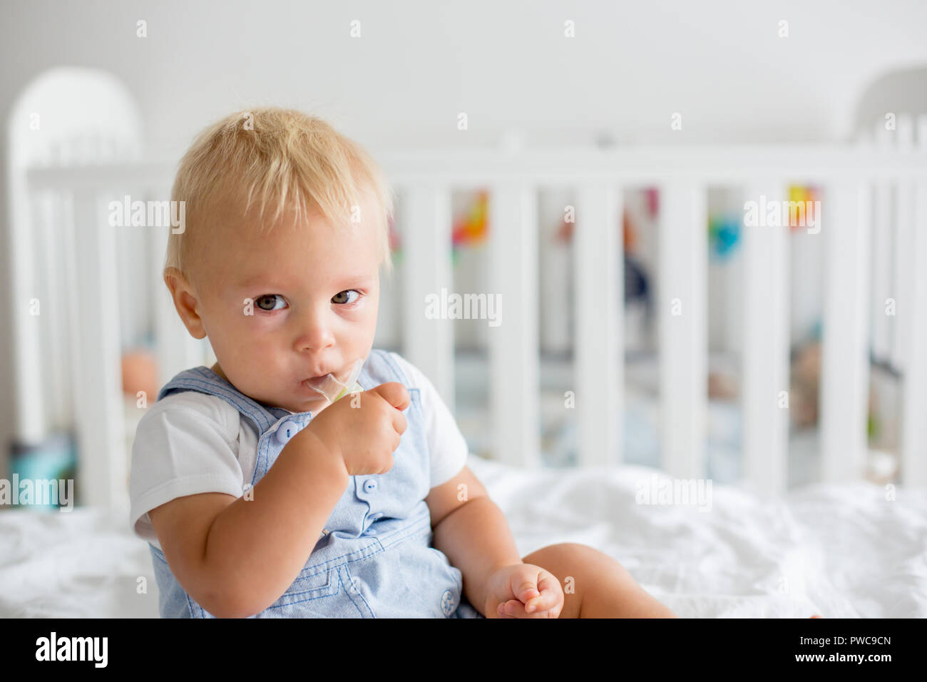 Toddler baby boy, playing with dummy, crying unhappy for the pacifier ...