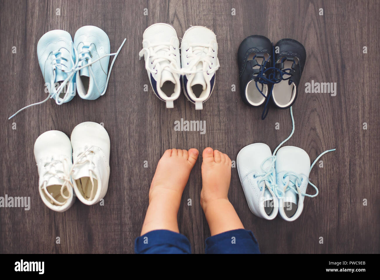 Children shoes and baby feet on a wood background, isolated Stock Photo ...