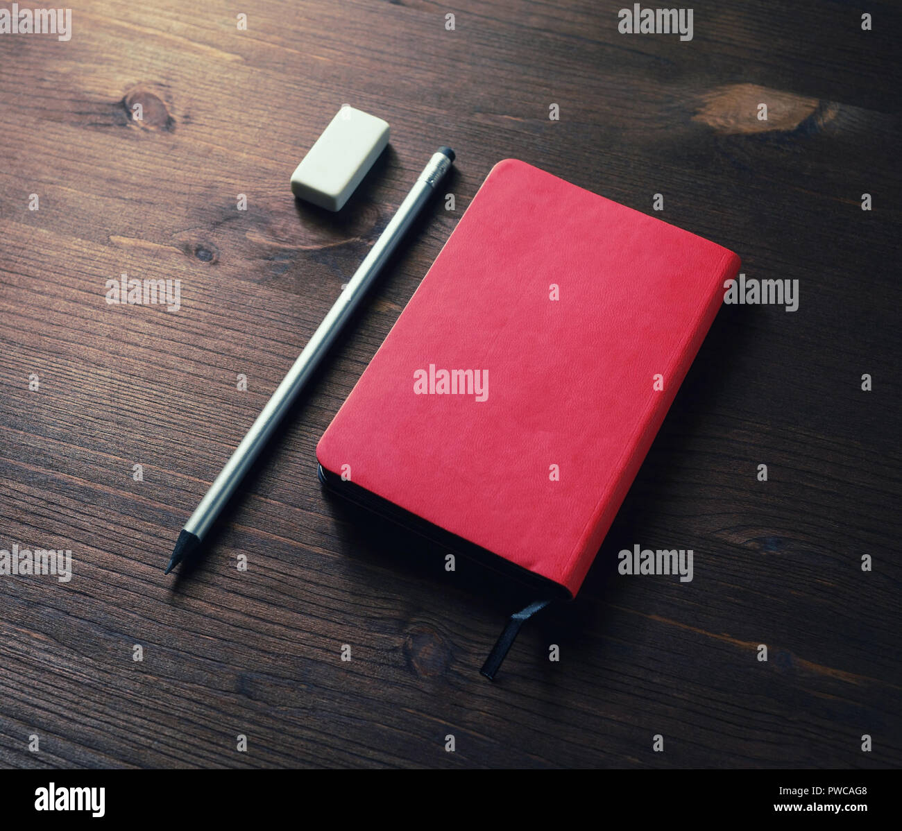 Red notepad, pencil and eraser on dark wood table background Stock ...