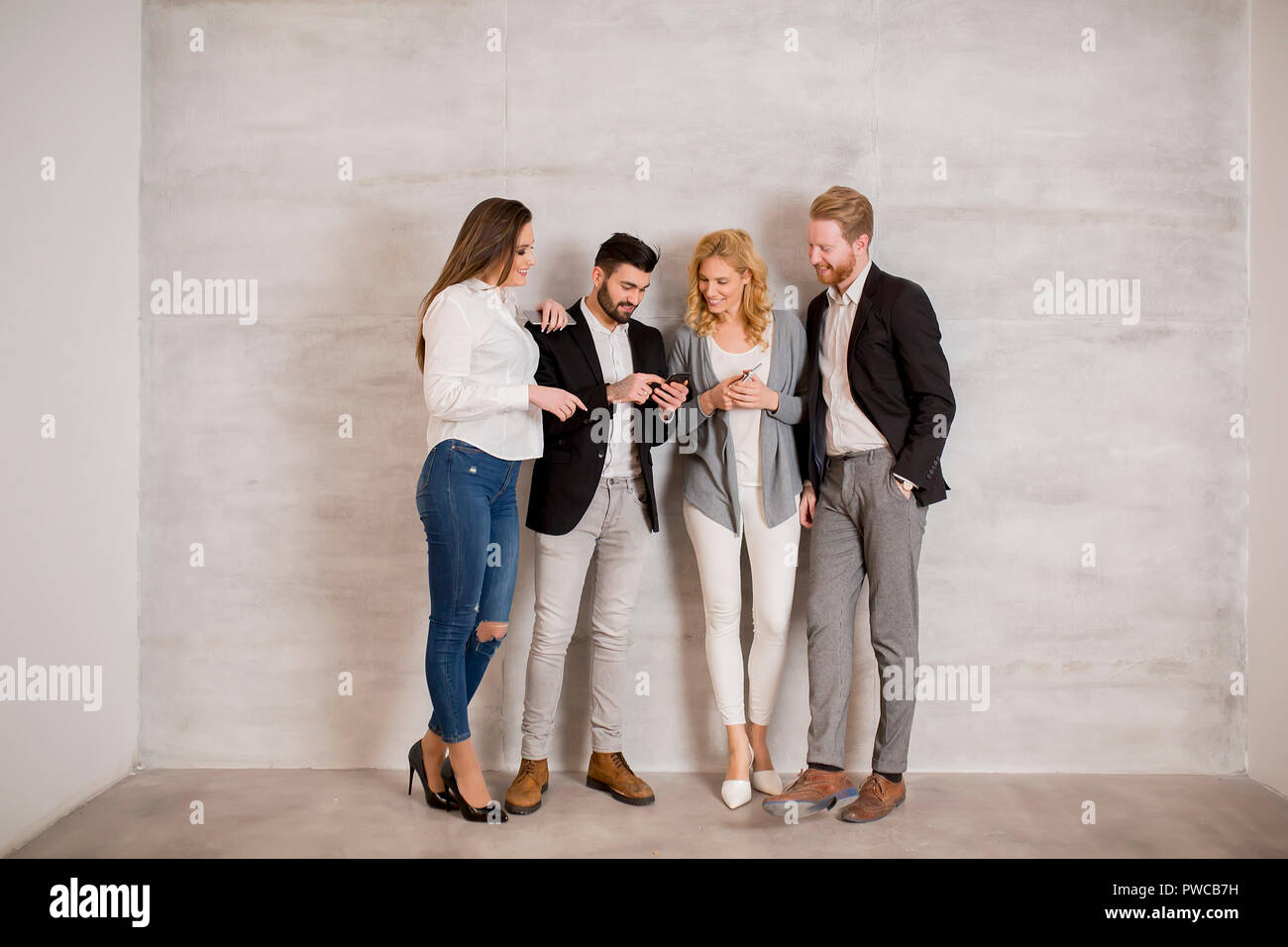 Group of young good looking people standing together over wall ...