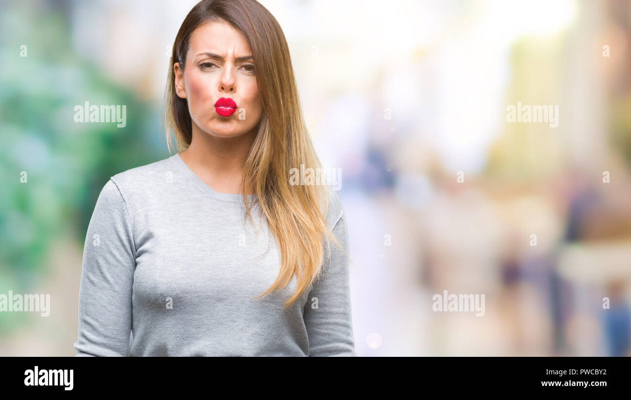 Young beautiful worker business woman over isolated background puffing ...