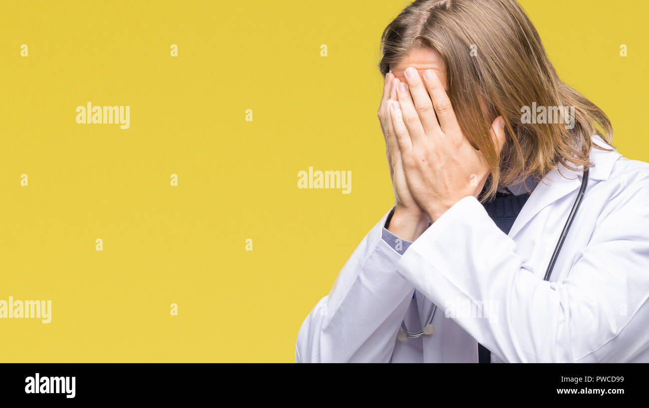 Young handsome doctor man with long hair over isolated background with ...