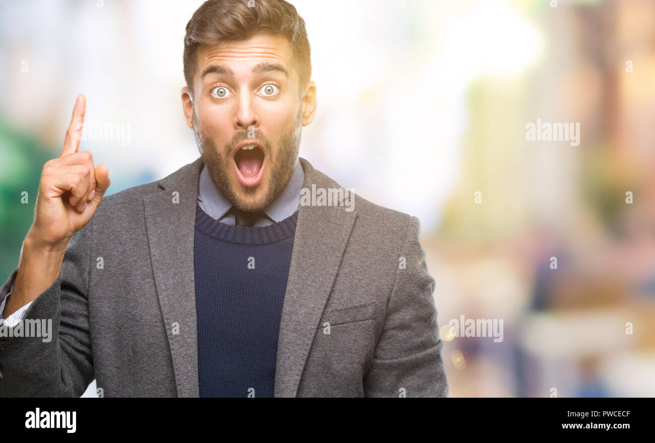 Young handsome business man over isolated background pointing finger up ...