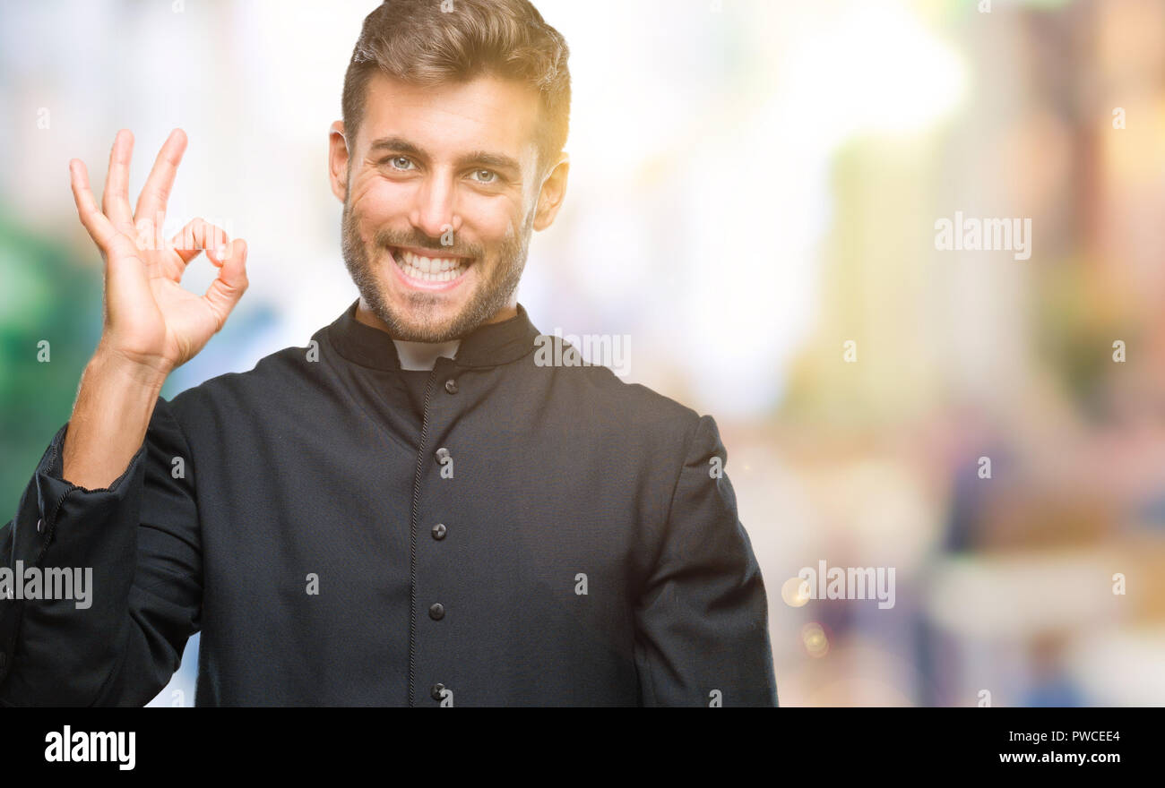 Young catholic christian priest man over isolated background smiling ...
