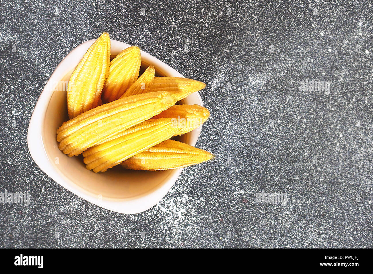 Baby sweetcorn or mini corn. It is typically the eaten whole cob ...