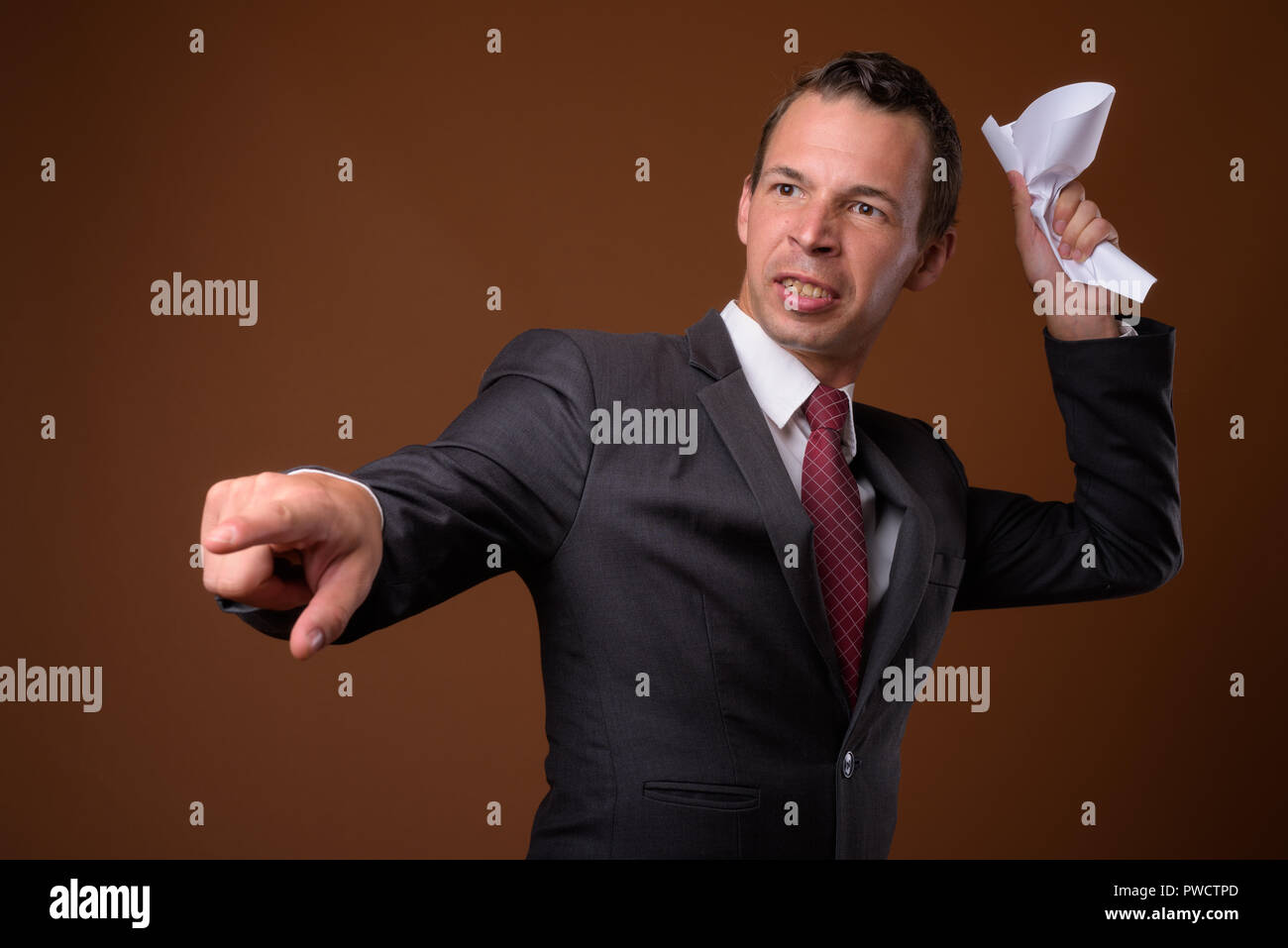 Studio shot of businessman against brown background Stock Photo - Alamy