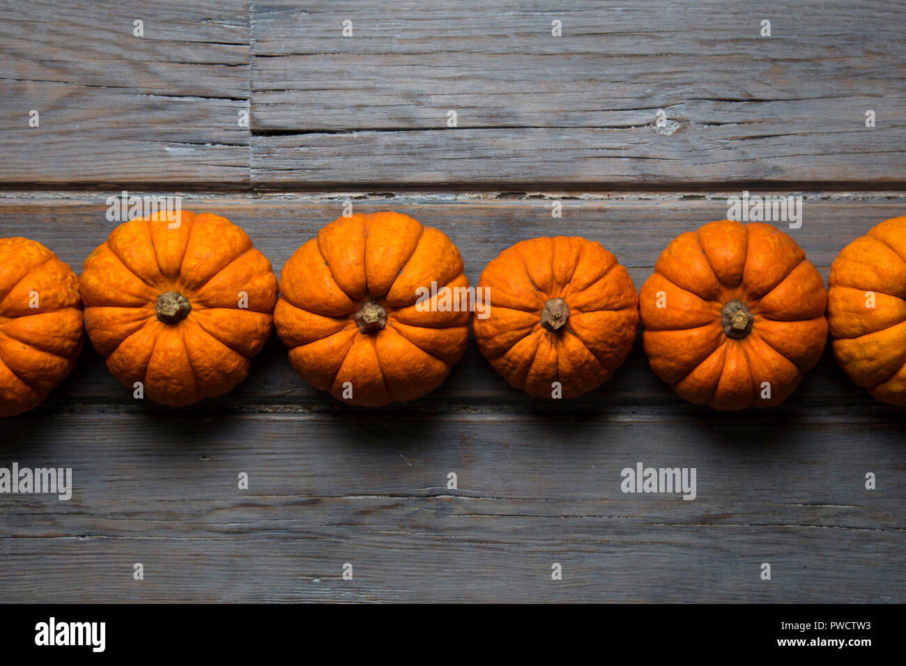 MIni pumpkins arranged on a rustic wooden background Stock Photo - Alamy