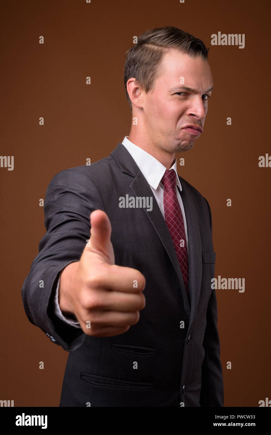 Studio shot of businessman against brown background Stock Photo - Alamy