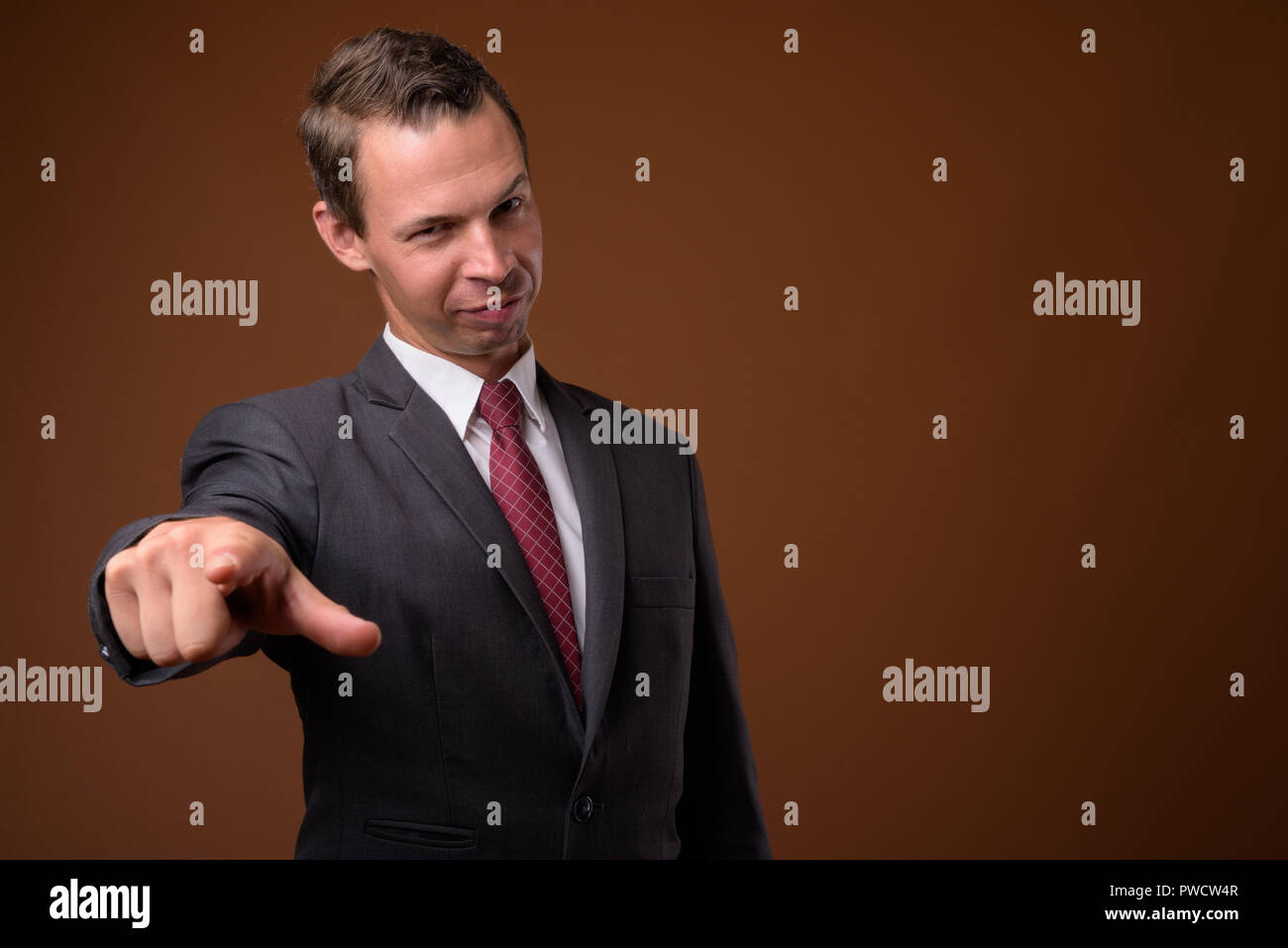 Studio shot of businessman against brown background Stock Photo - Alamy